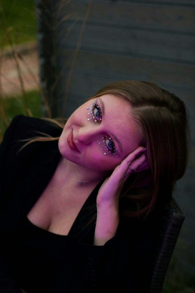 Young woman with artistic glitter makeup posing outdoors in France.